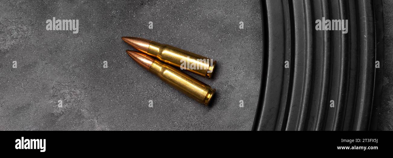 Two bullets for Kalashnikov assault rifle on gray concrete and gradient ...