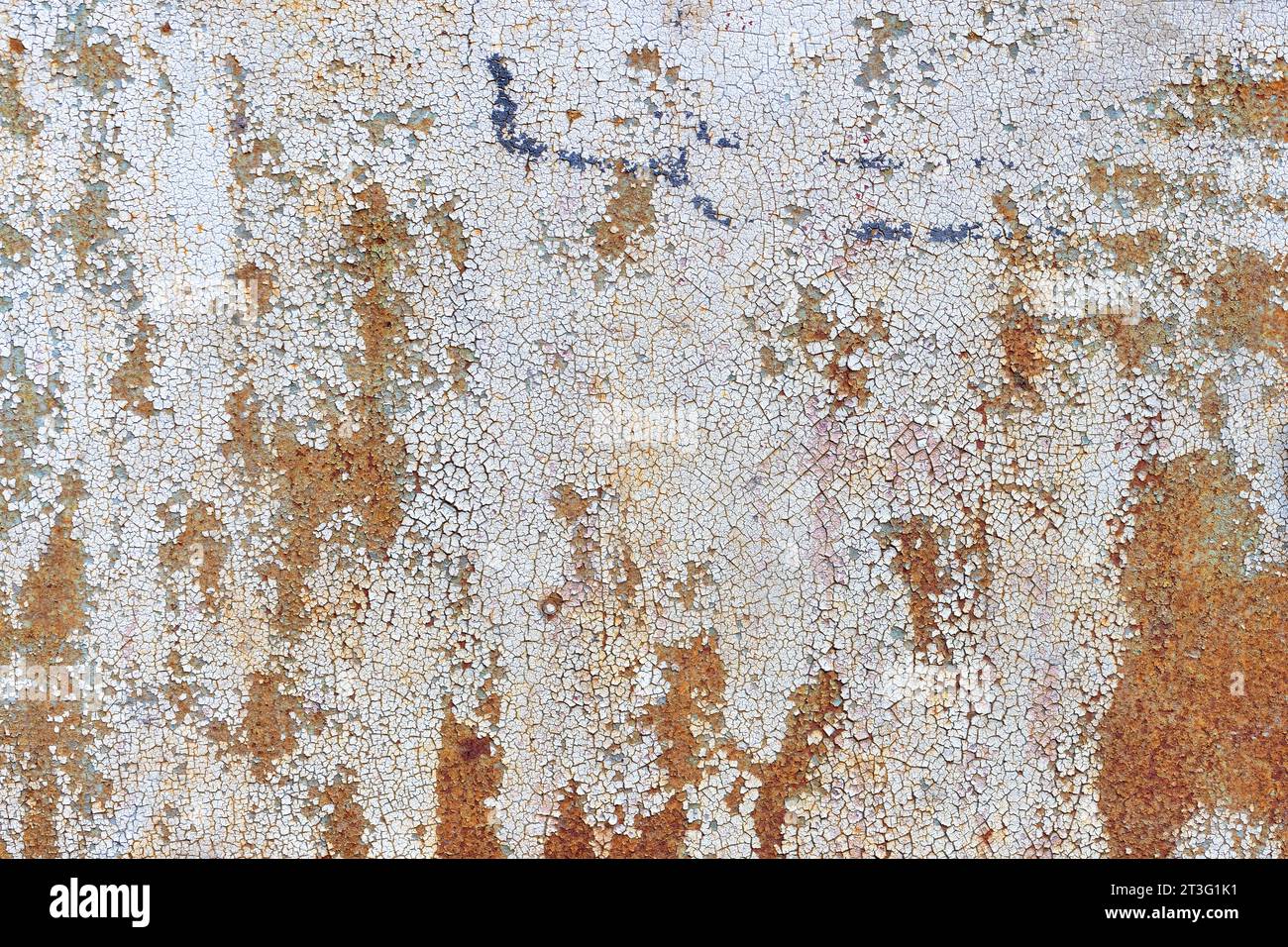 An old coat of white paint with a cracked texture covers a metal ...