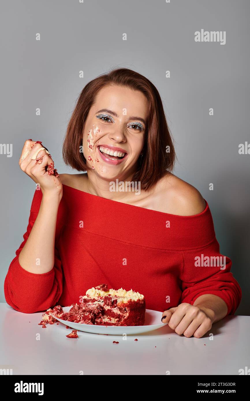 positive birthday girl with dirty face eating delicious red velvet cake ...