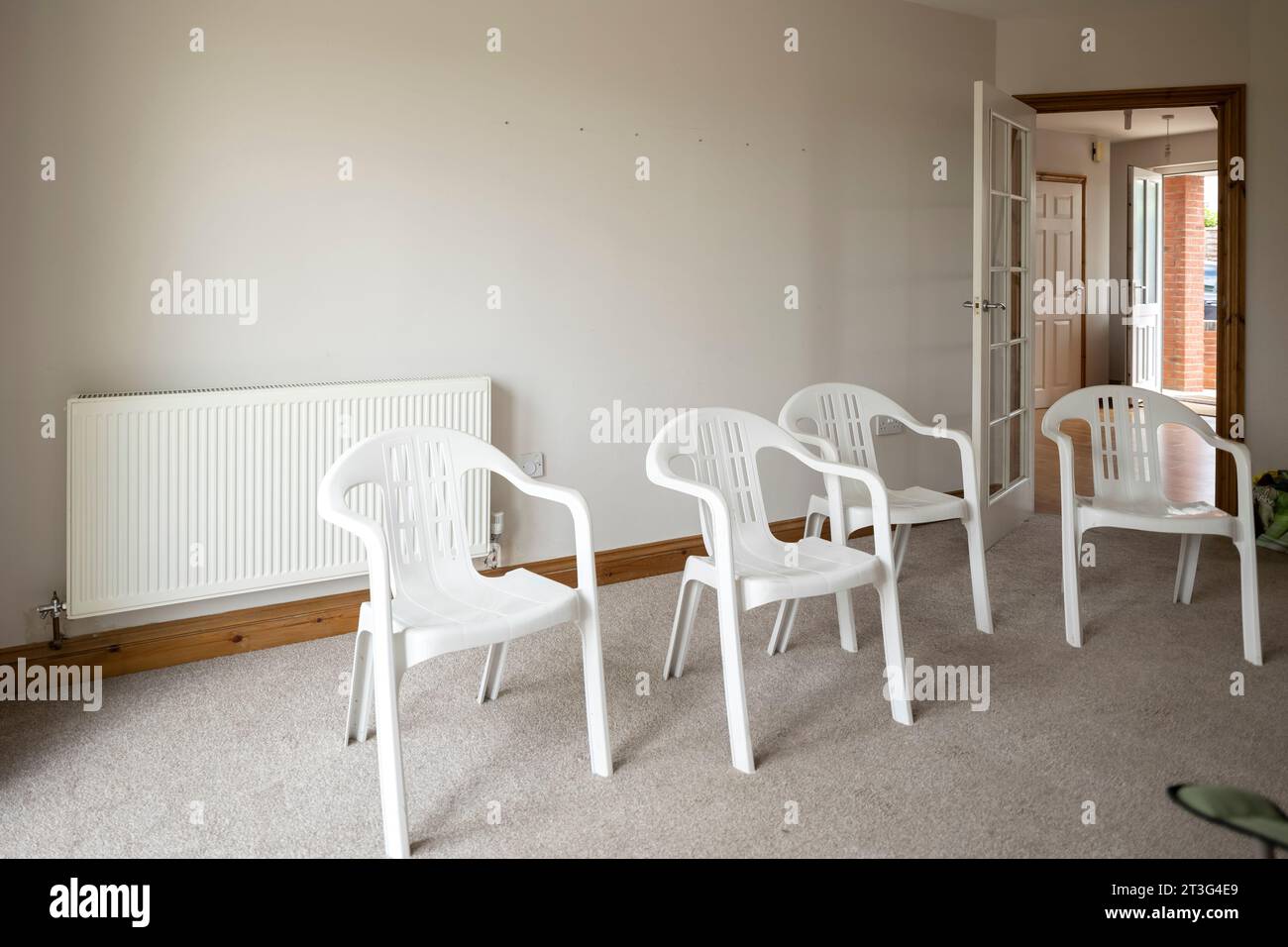 Empty lounge on moving in day, with basic plastic chairs Stock Photo ...