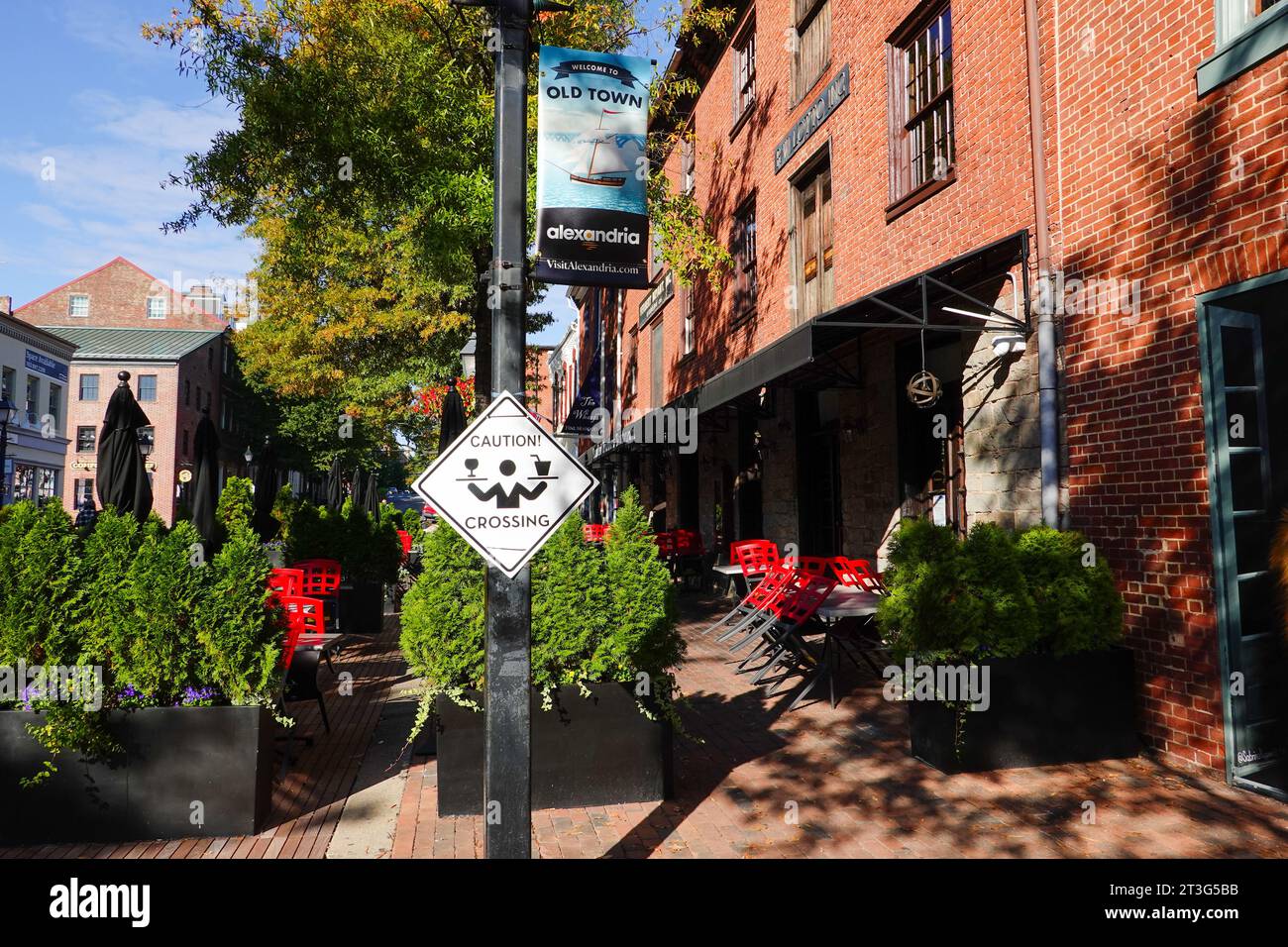 Caution "waiter crossing" sign, early autumn morning in outdoor seating ...