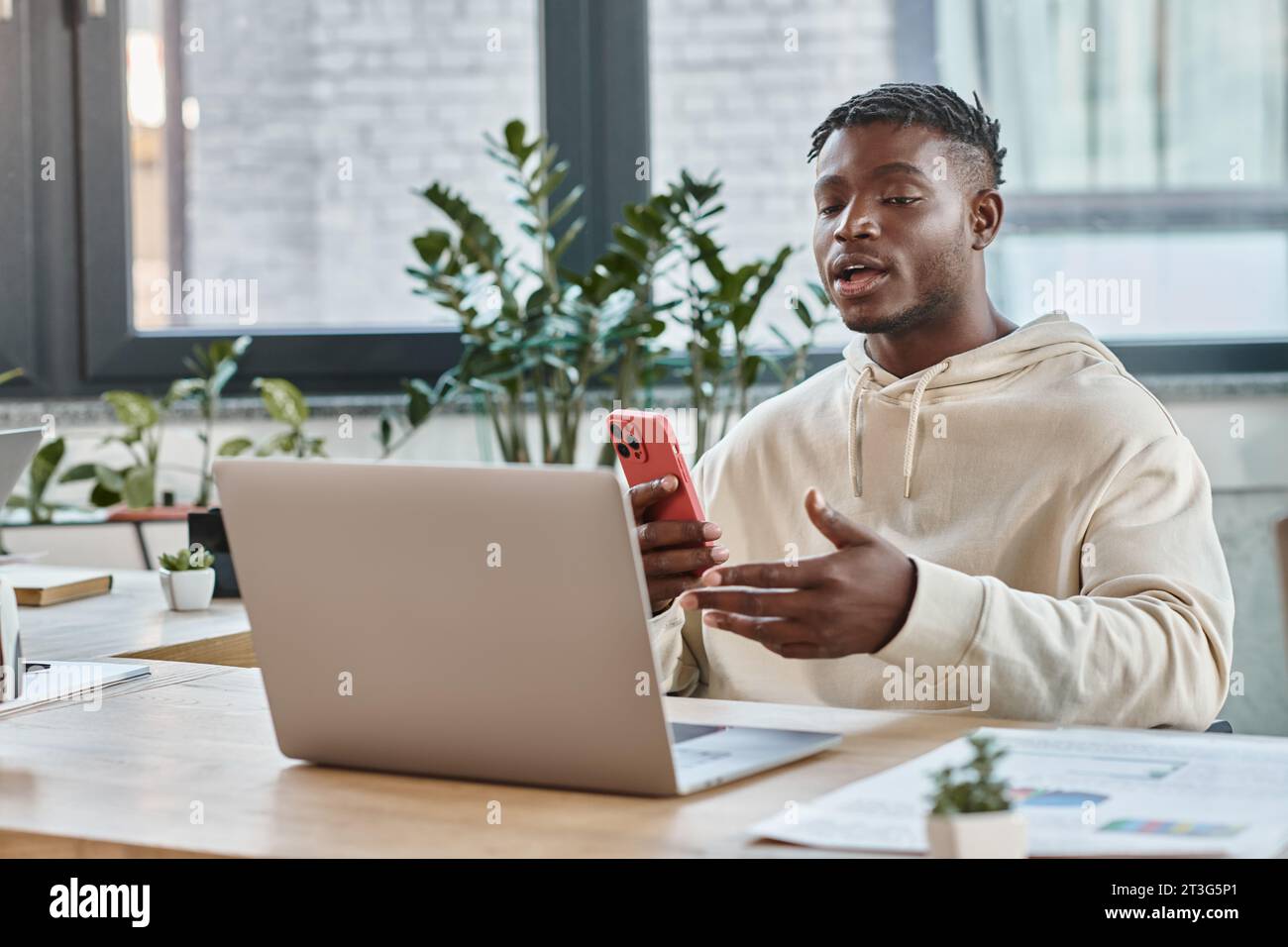 stylish african american man talking to someone by laptop and gesturing ...