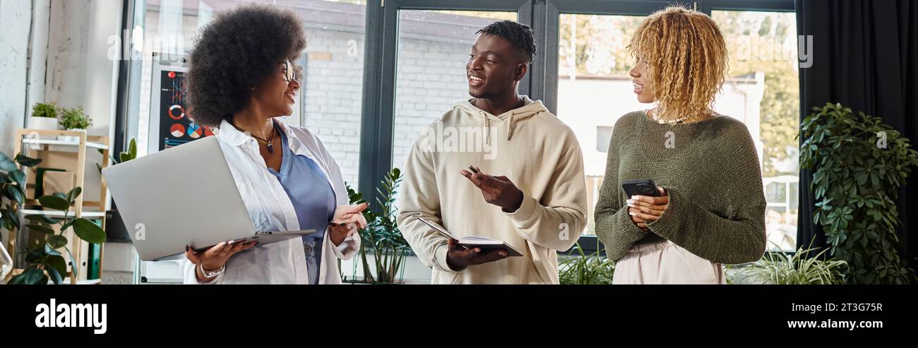 cheerful young friends discussing their project with graphics on ...