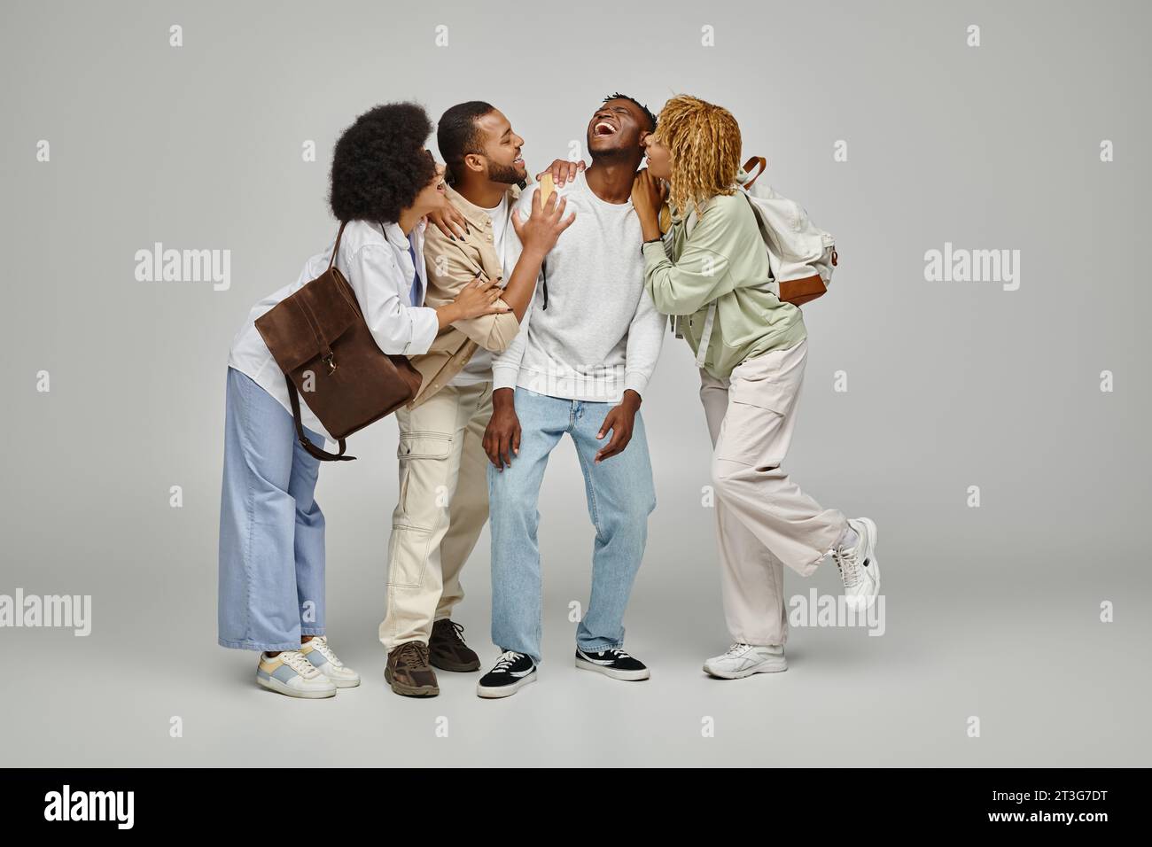 cheerful caring group of friends hugging and laughing together on gray ...