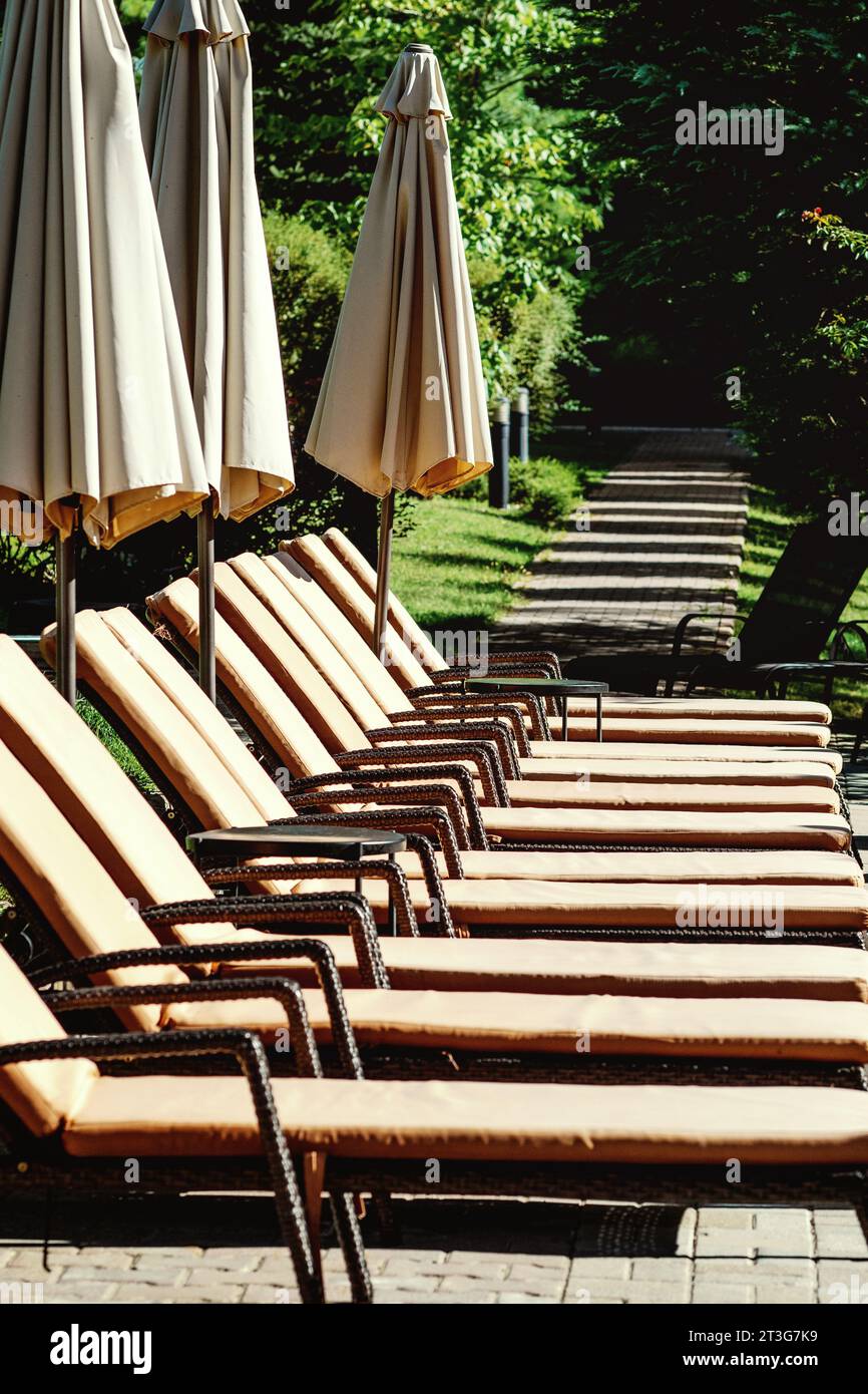 Empty sun loungers stand in row. Empty resort and vacation spot. End of ...