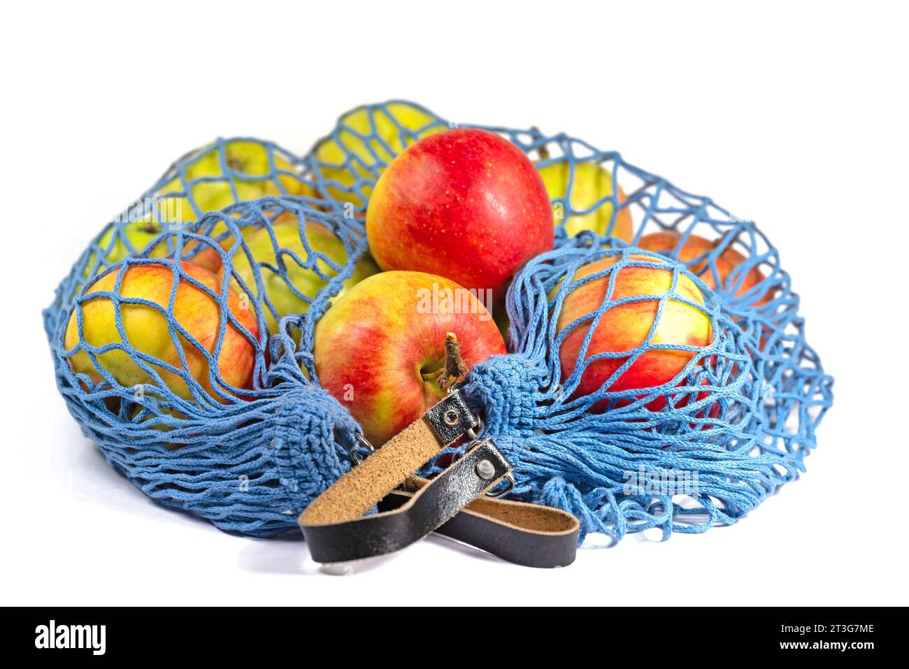 Apples in the net against a white background Stock Photo - Alamy