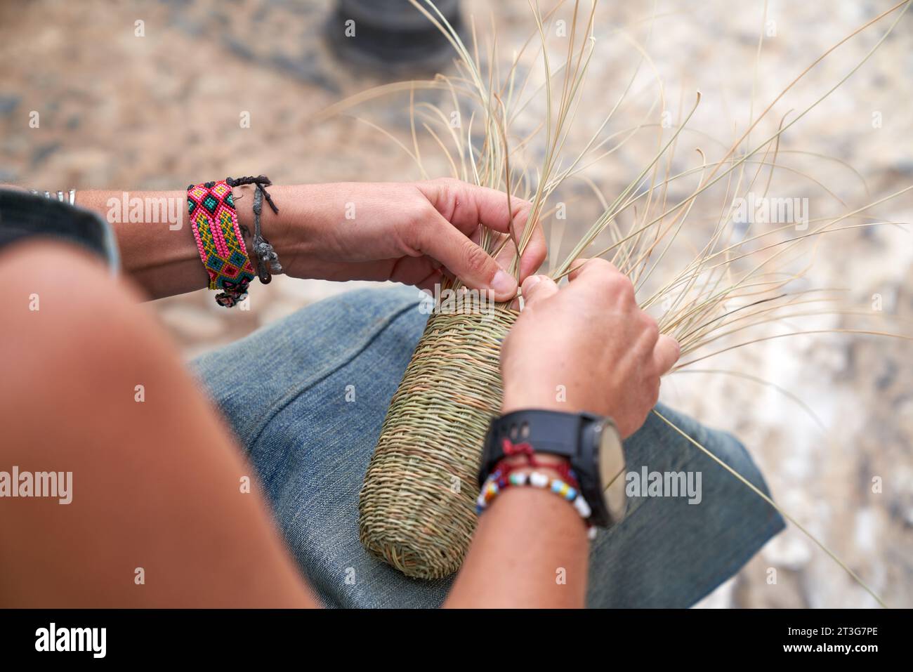 Abobe view of Hispanic woman weaving a basket with esparto fibers ...