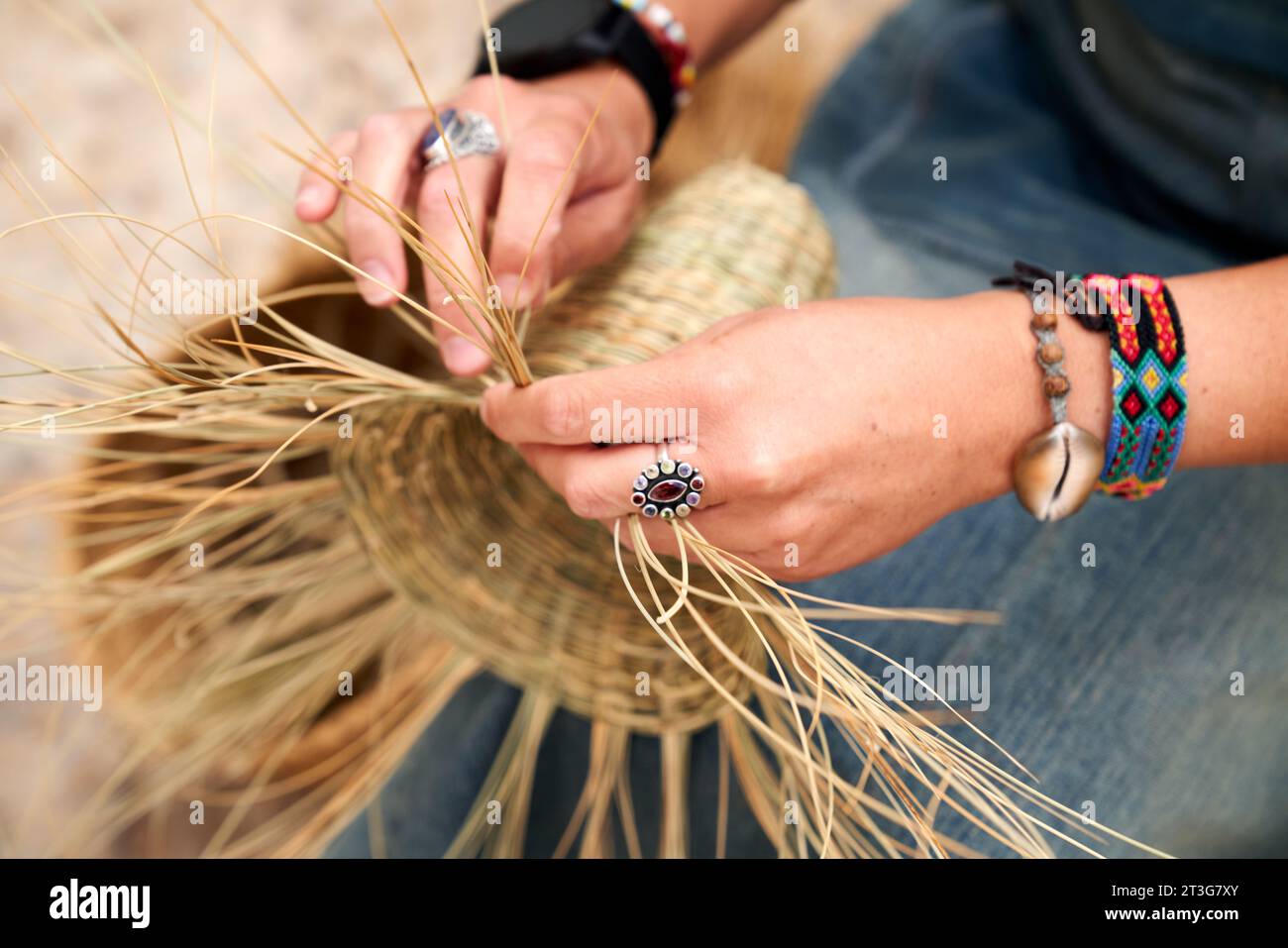 Abobe view of Hispanic woman weaving a basket with esparto fibers ...