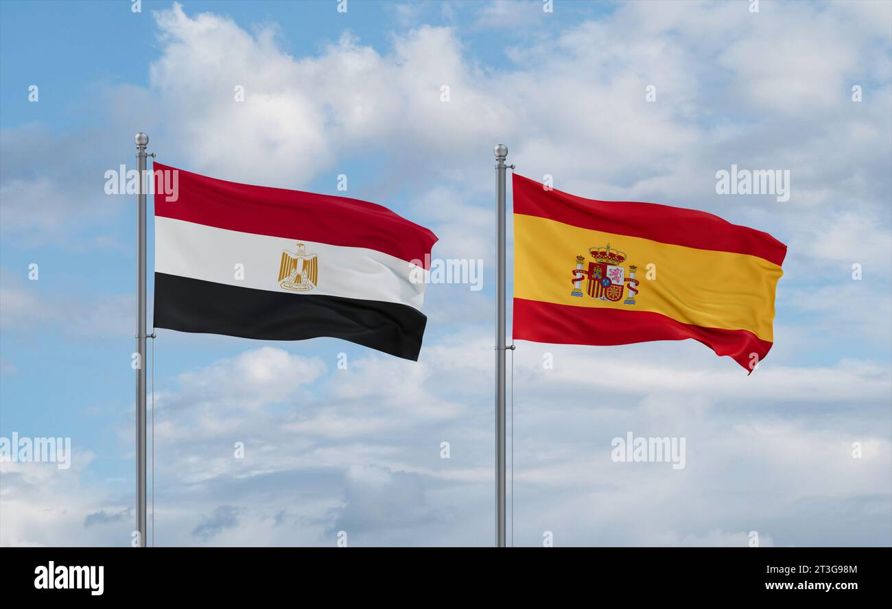 Spain and Egypt flags waving together in the wind on blue cloudy sky ...