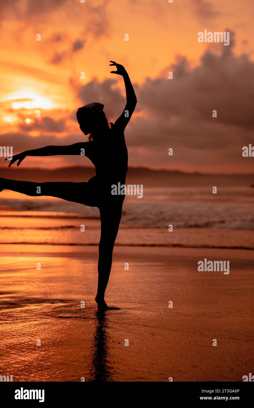 silhouette of a very slender ballerina doing ballet practice alone on ...