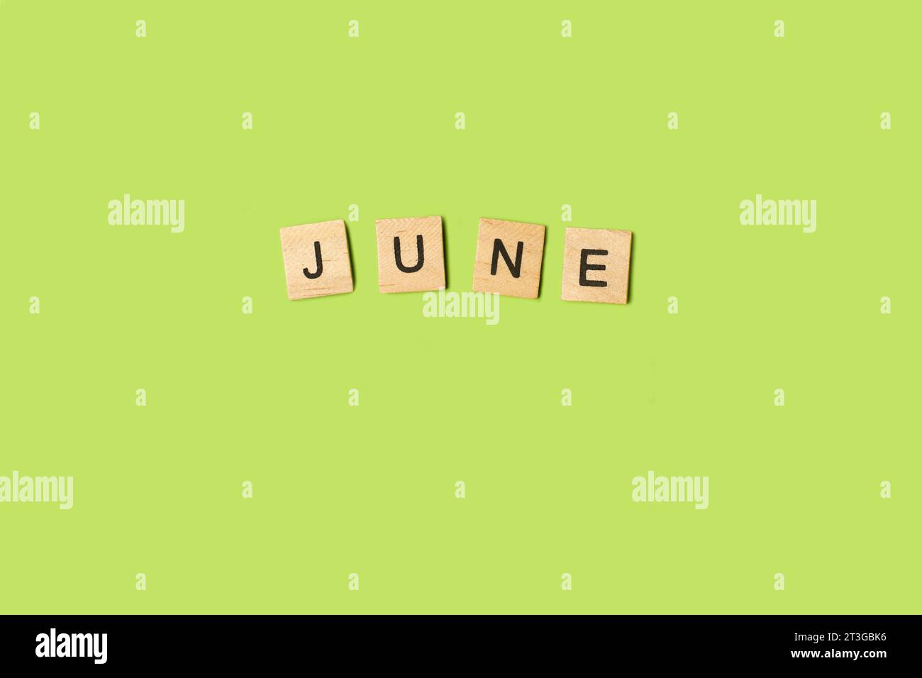 June single word made with wooden letter blocks on an green background ...