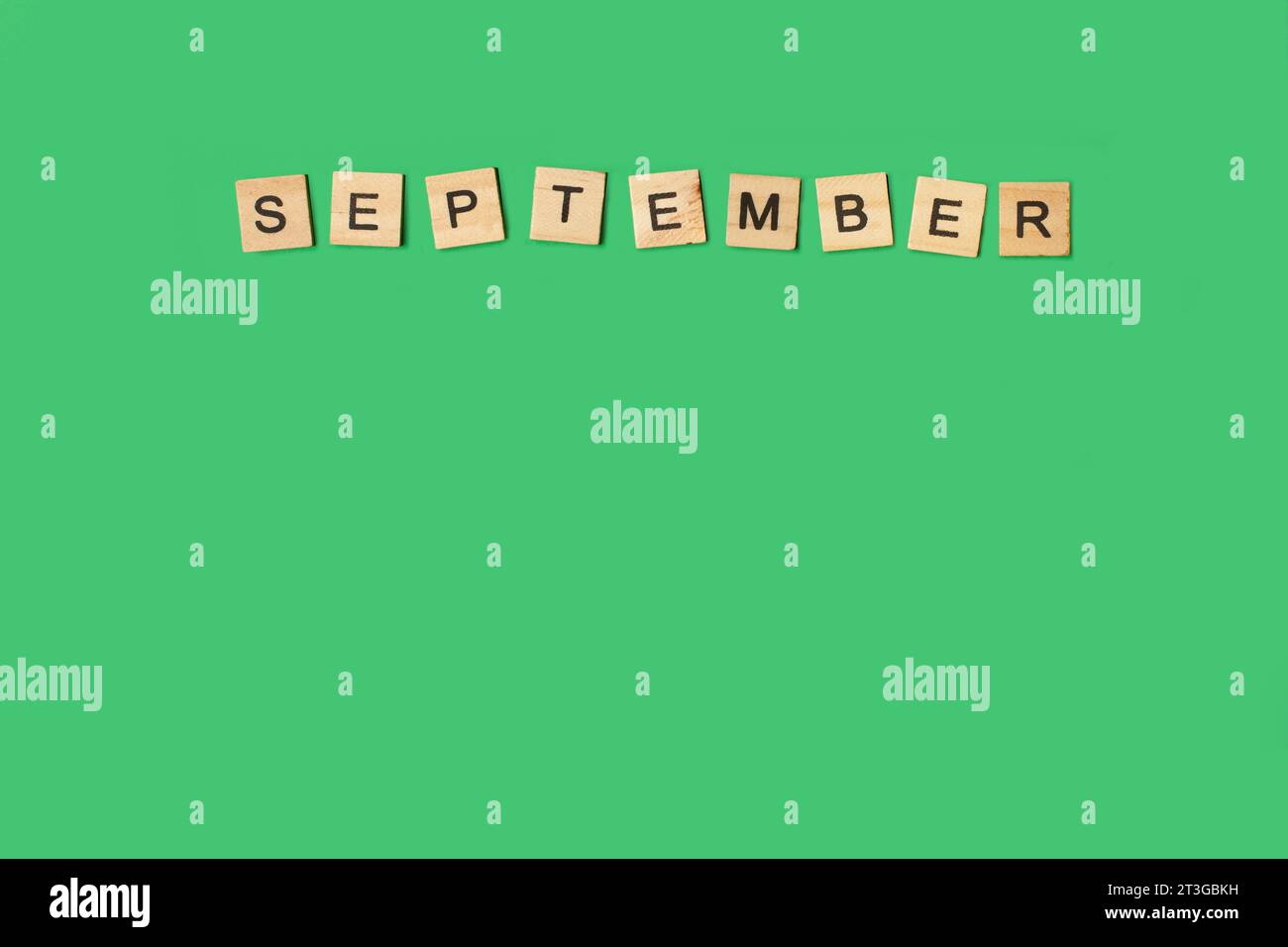 September word made with wooden letter blocks on a green background ...