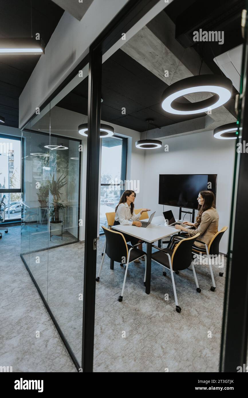 Young business women discussing in cubicle at the modern office Stock ...