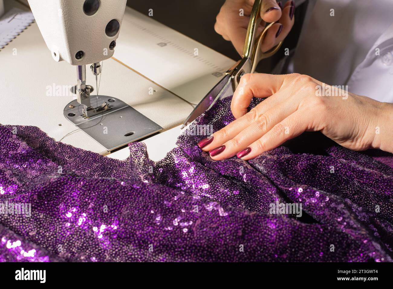 Tailor hands at work on sewing machine and scissors close-up fashion ...