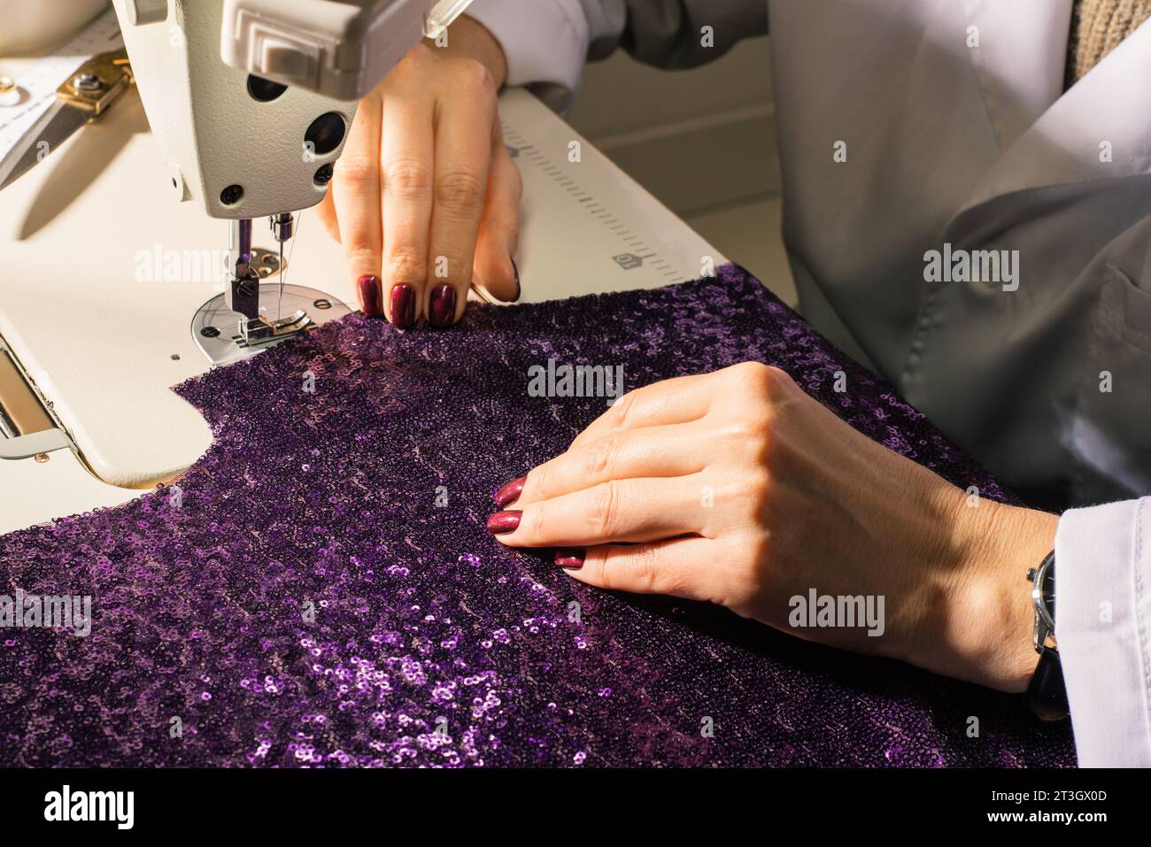Tailor hands at work on sewing machine and scissors close-up fashion ...