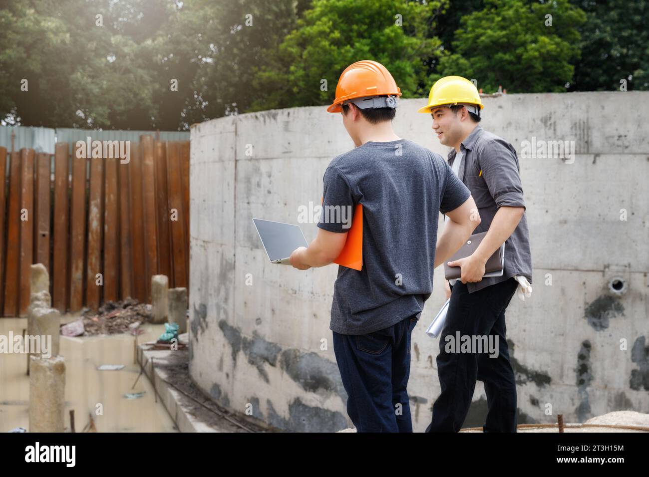 Team of construction workers discussing project details with blueprint ...