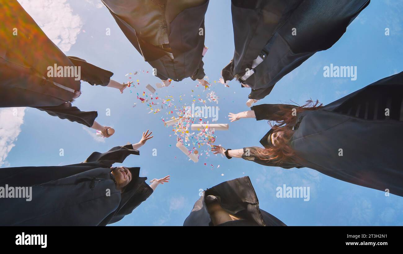College graduates toss diplomas with confetti up in the air Stock Photo ...