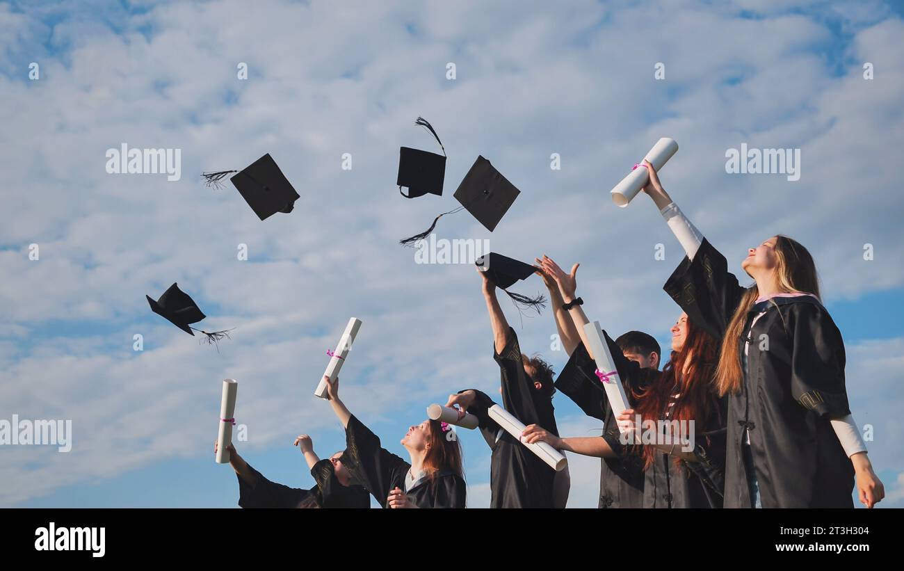 Graduating students hands throwing graduation caps in the air Stock Photo - Alamy