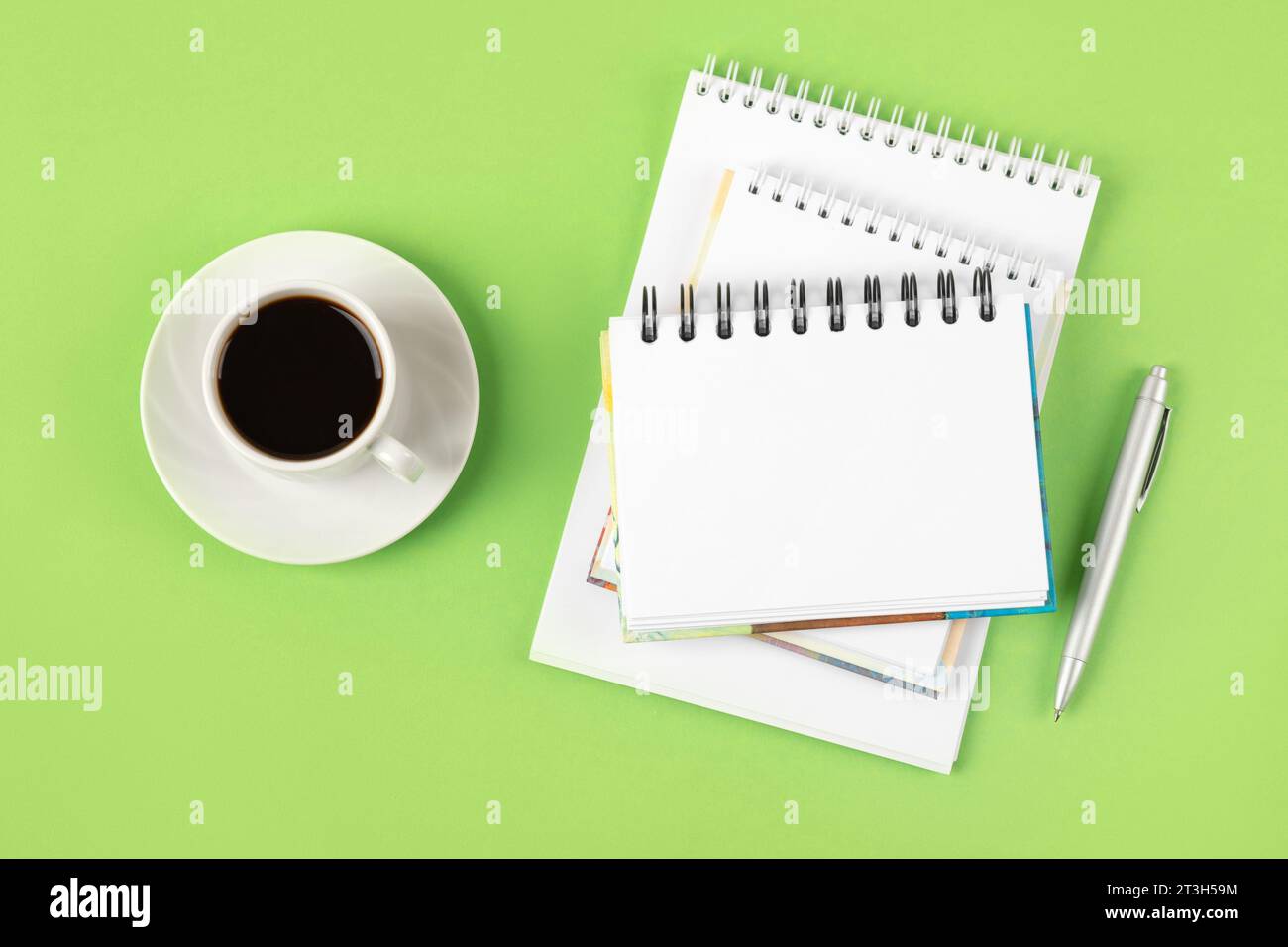 Composition with opened blank notepad and pen, cup of black coffee on a ...