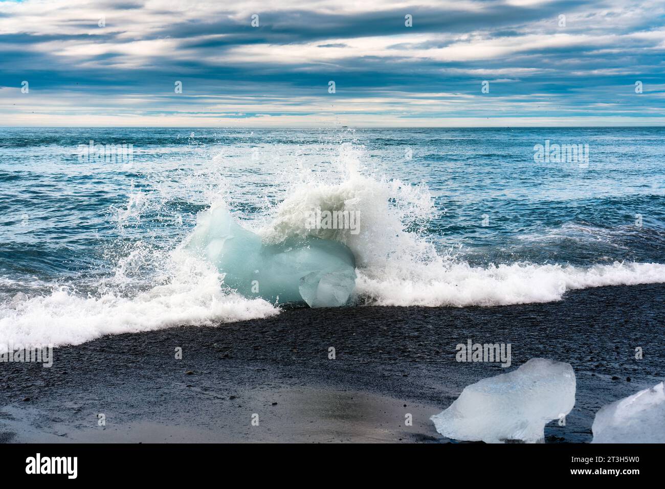 Wave crashing with iceberg on black sand beach in Diamond beach during ...
