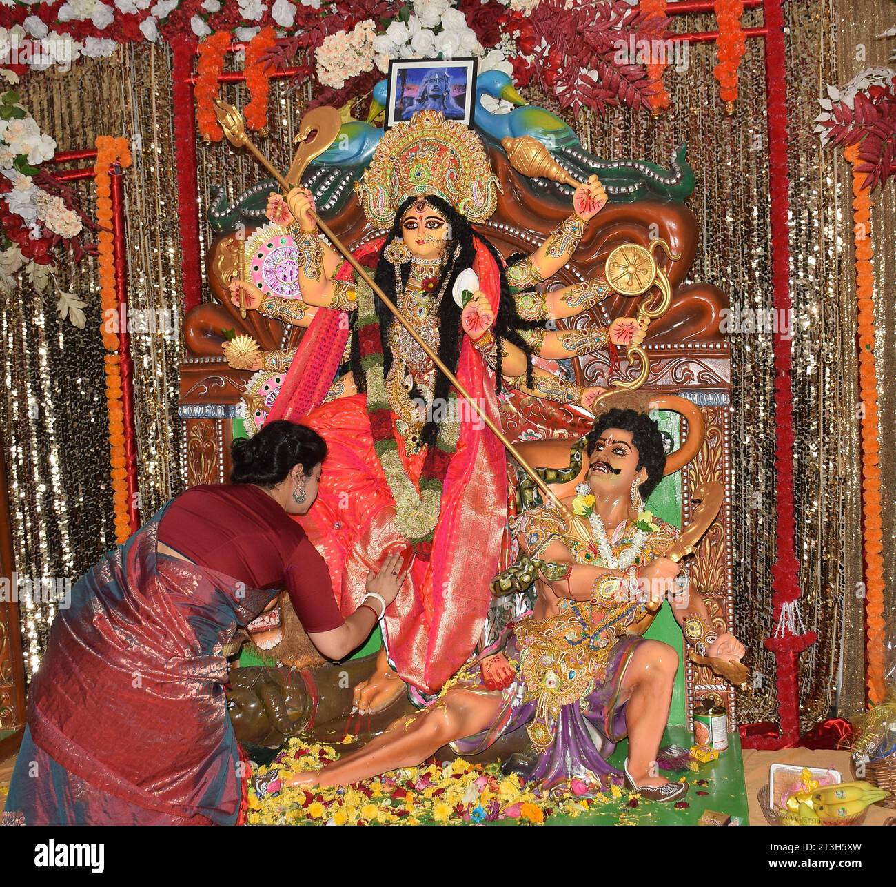 Bengali women devotee worshipping goddess Durga deity by touching its ...