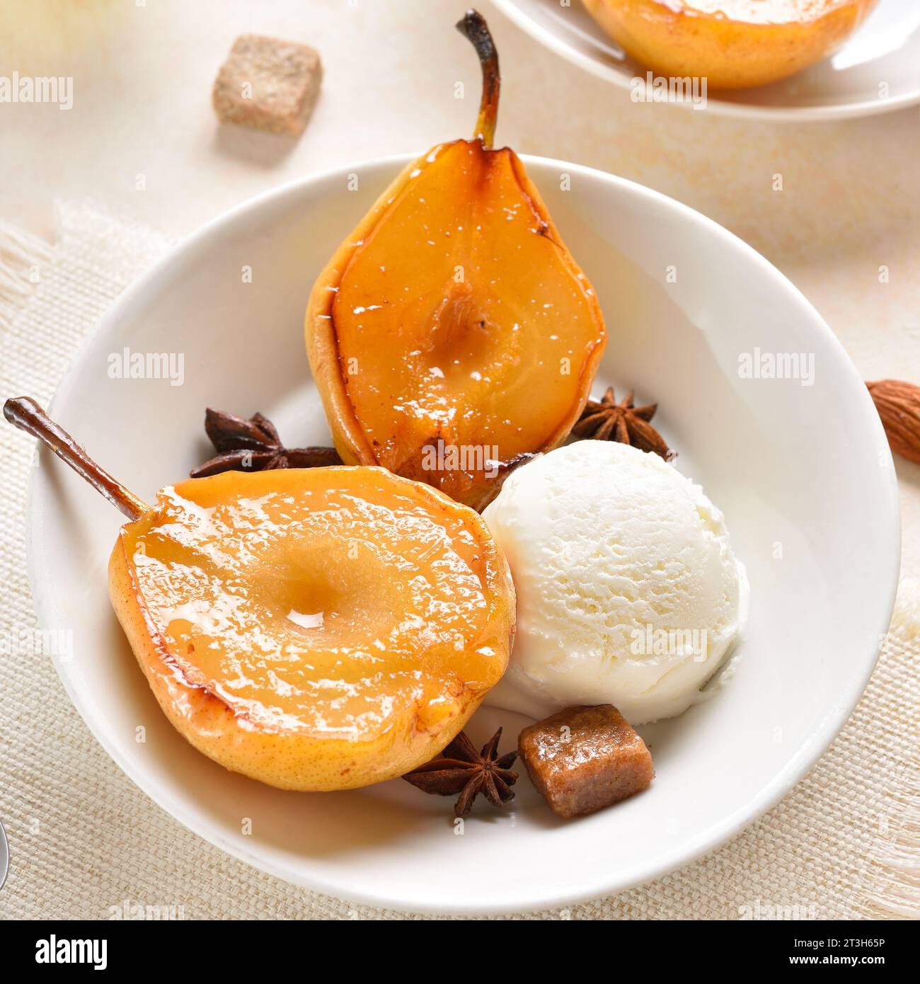 Ice cream ball with poached pears in bowl over light stone background ...