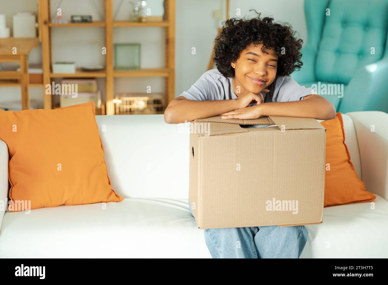 African girl unpacking delivery looking in box. Happy woman opening ...