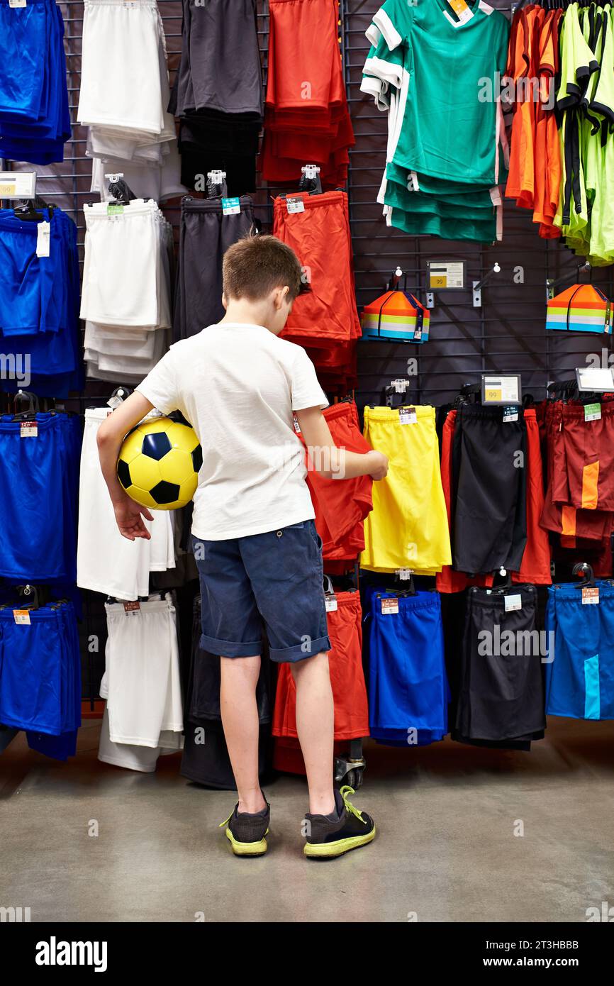 Boy with a ball in a football clothing store Stock Photo - Alamy