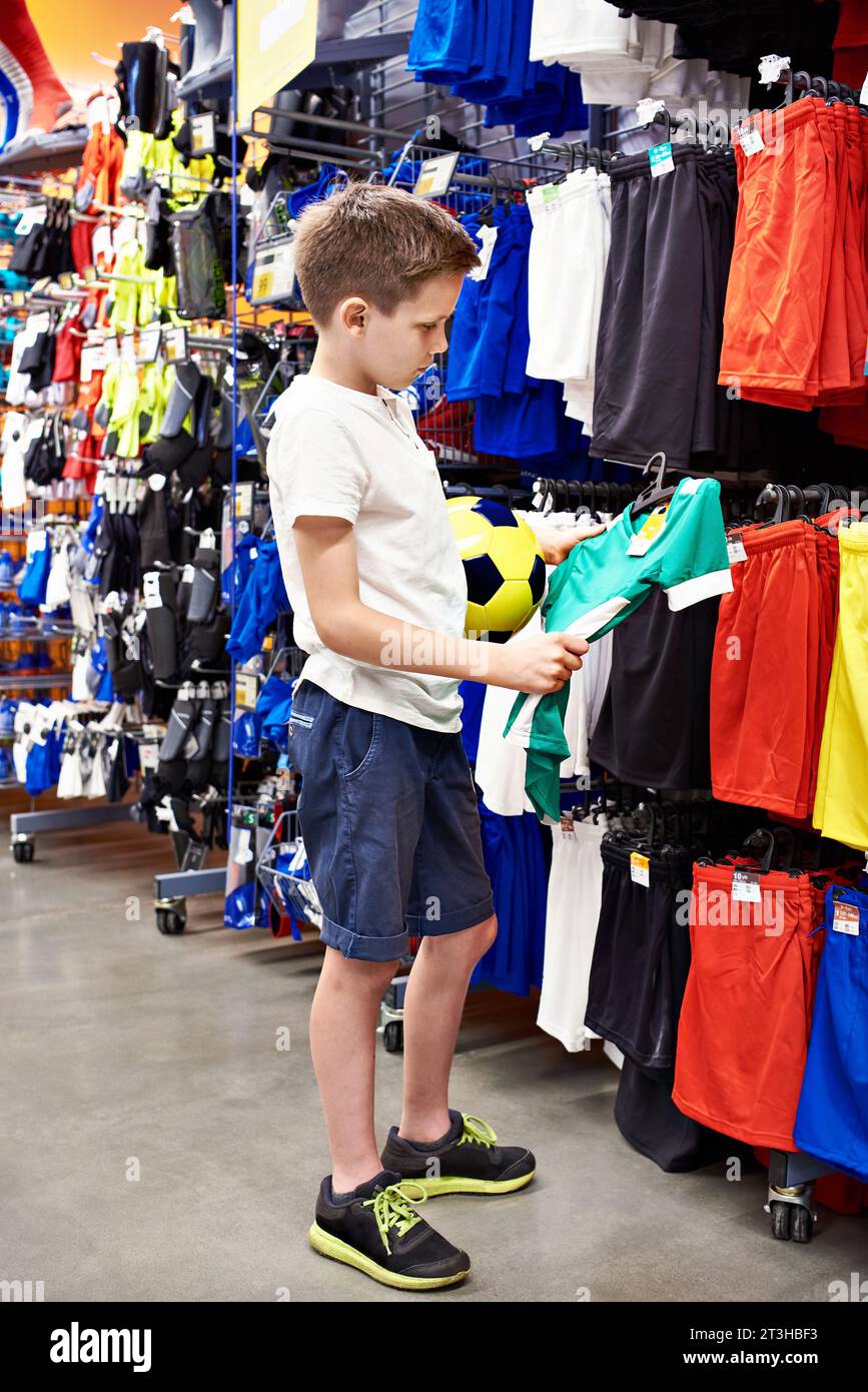 Boy with a ball in a football clothing store Stock Photo - Alamy