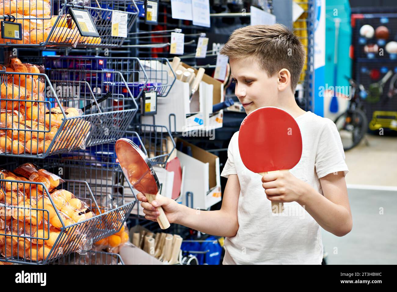 Boy with rackets for table tennis in a sporting goods store Stock Photo ...