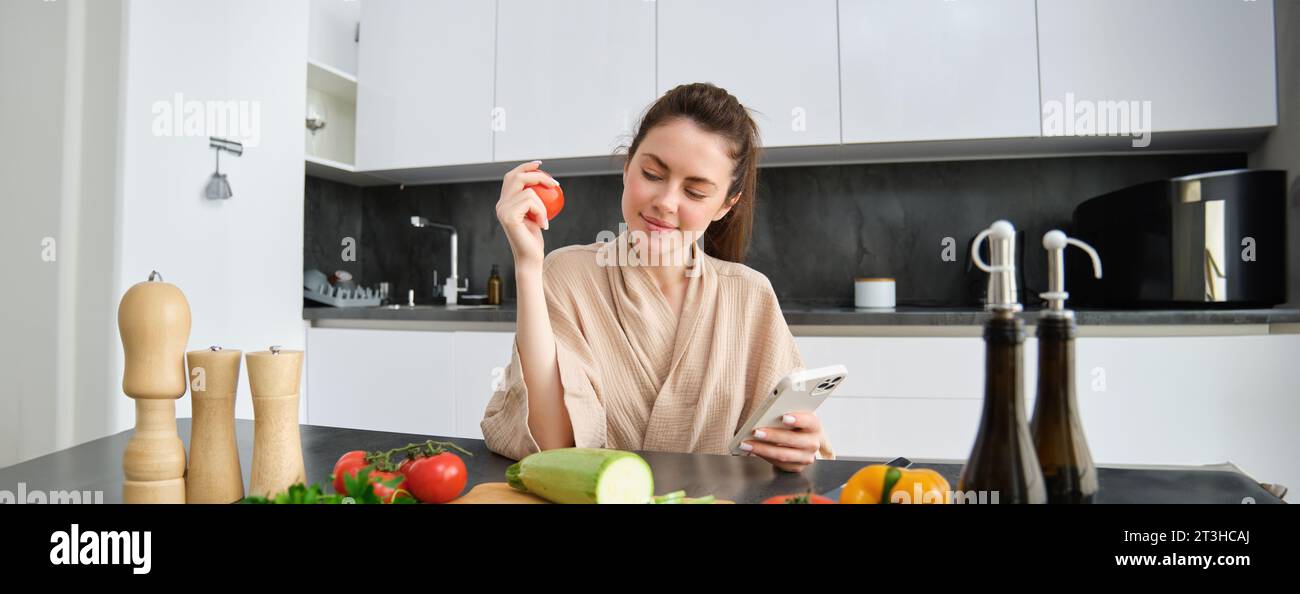 Image of young woman, chef on kitchen, cooking dinner at home, sitting ...