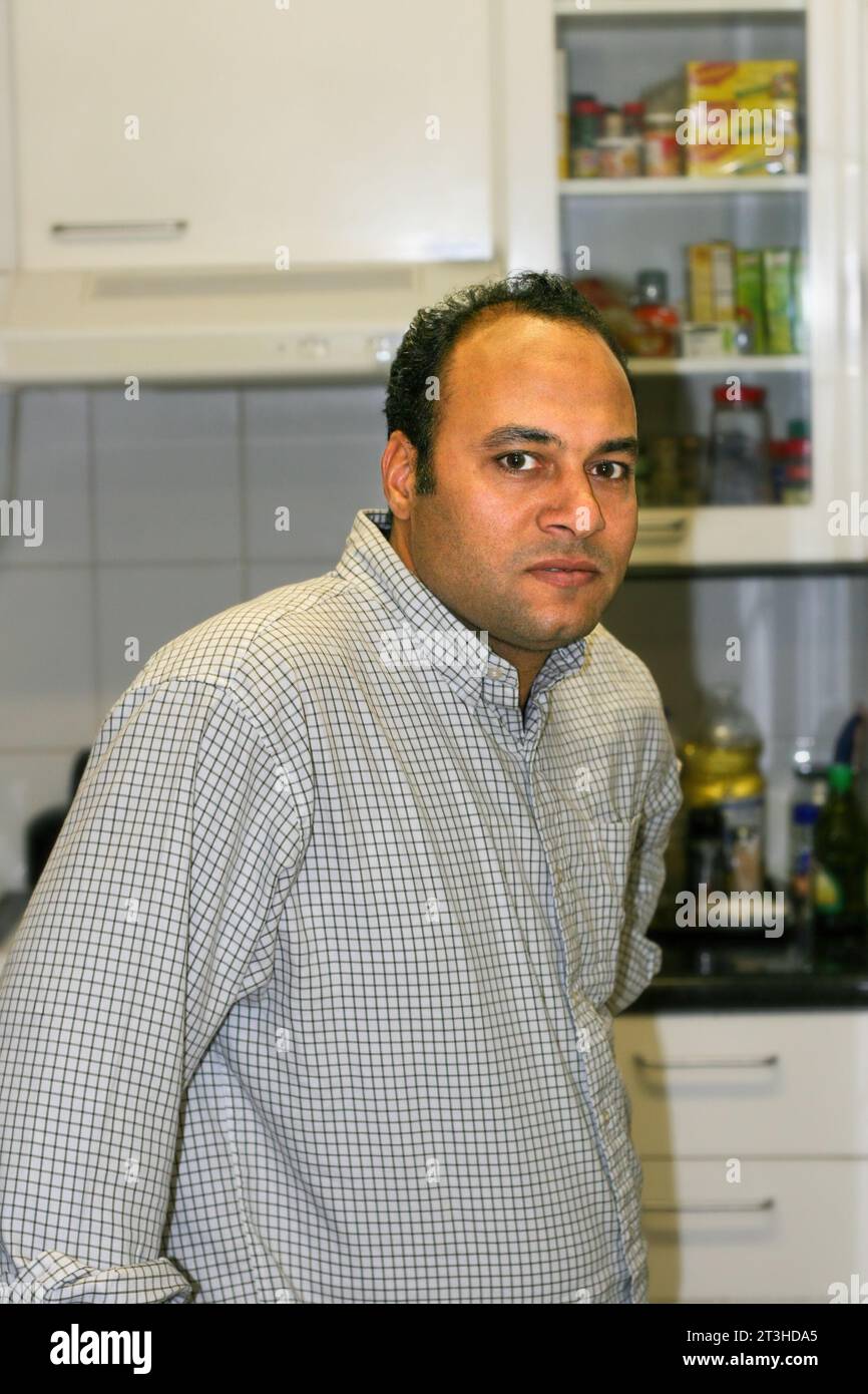 portrait of a arab Egyptian man in the kitchen at home preparing to do ...