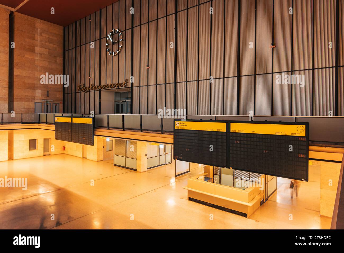 A clock and departure screens inside the old check-in hall at Tempelhof ...