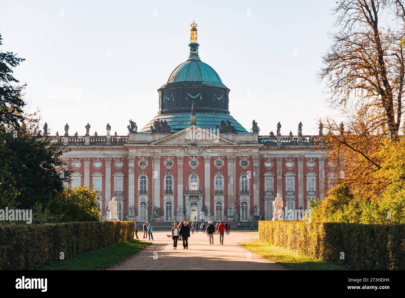 visitors walk down a long path toward the New Palace in Sanssouci Park ...