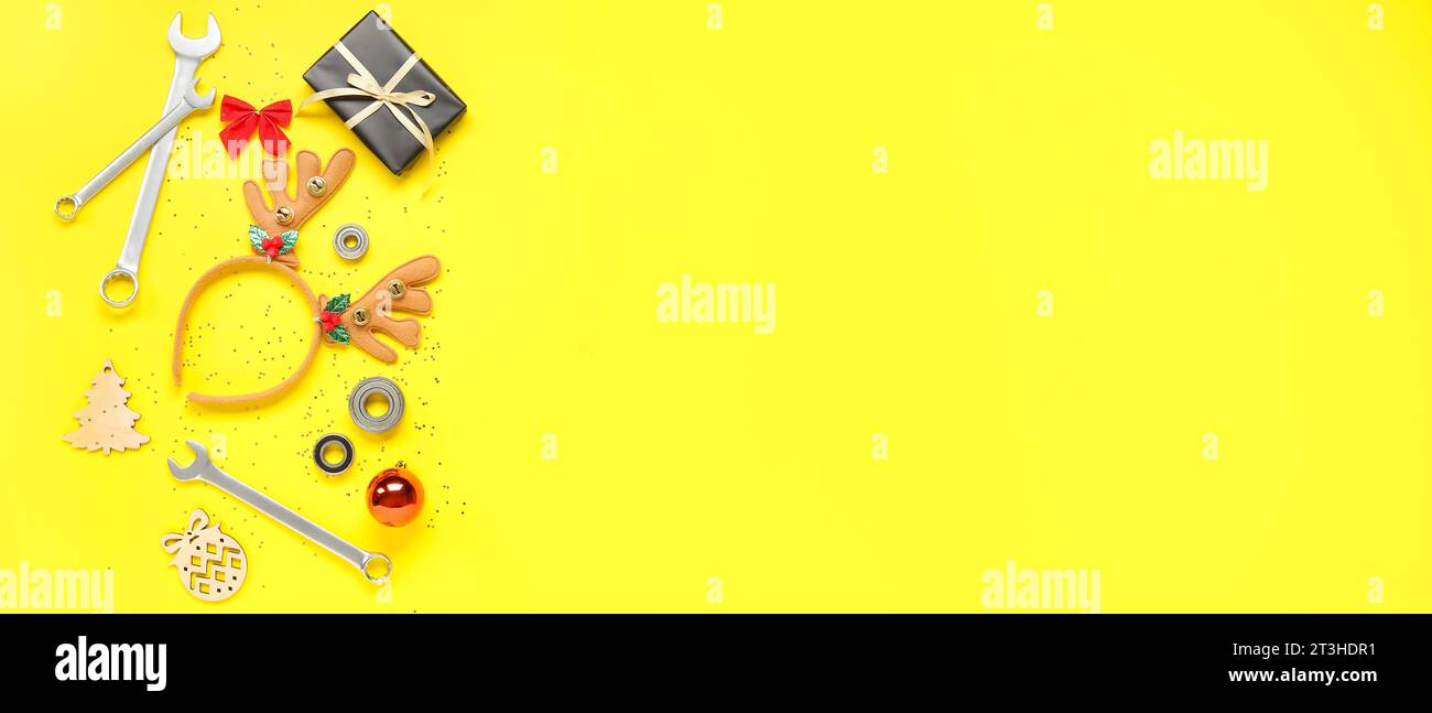 Construction tools with Christmas gift and decor on yellow background ...
