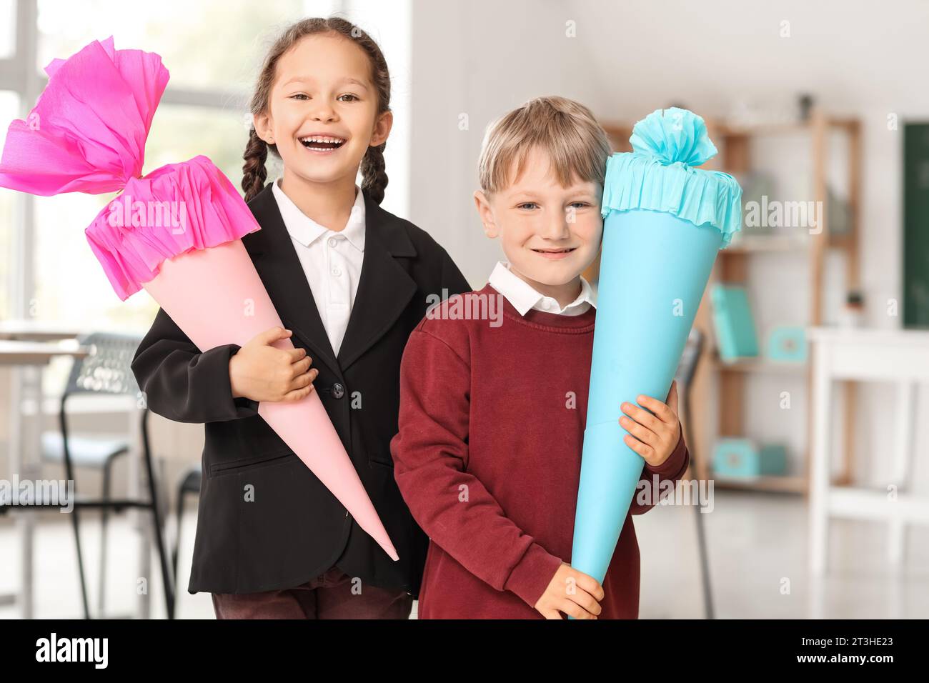 Happy classmates with colorful school cones in classroom Stock Photo ...
