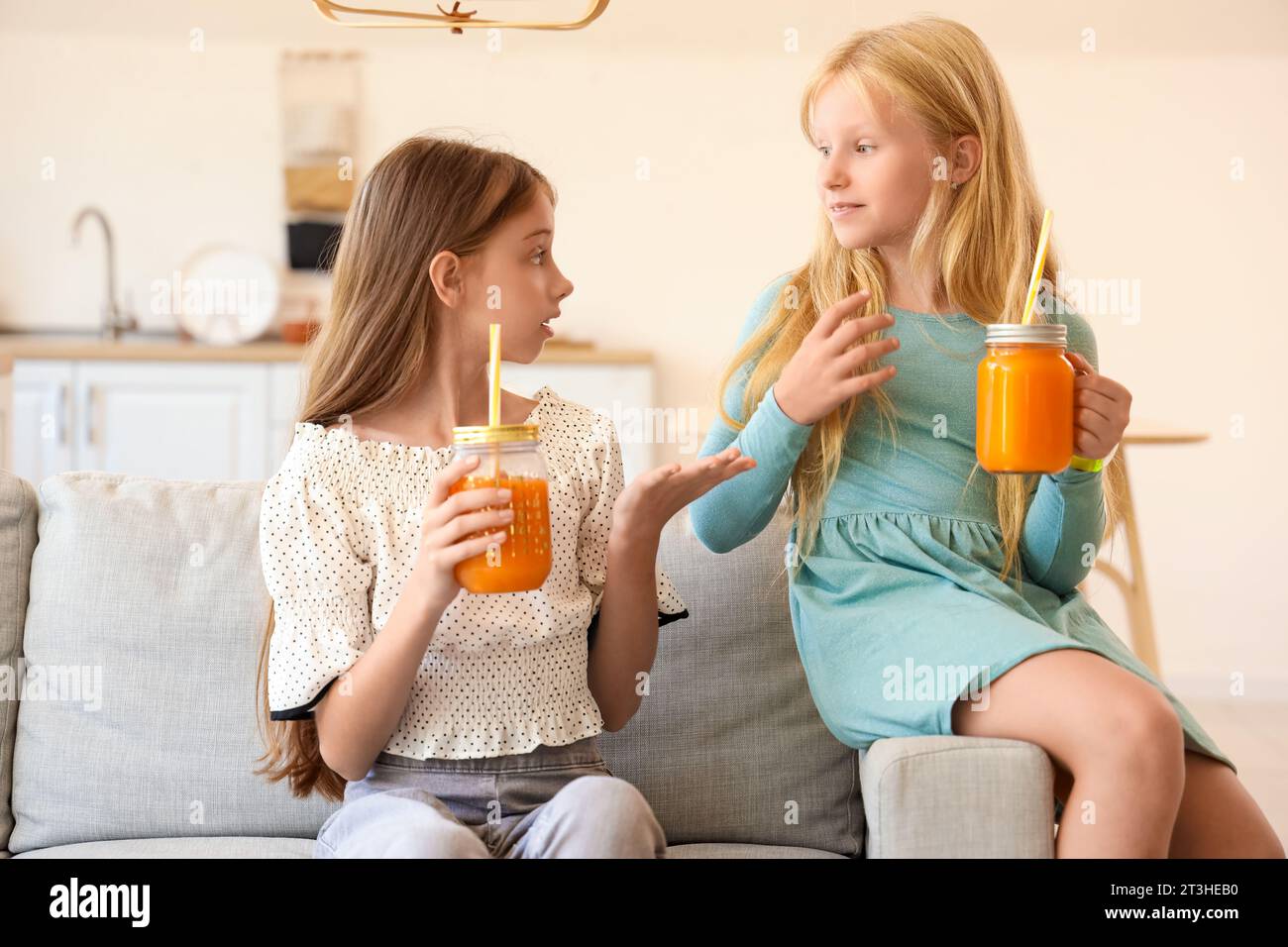 Little girls with glass jars of juice at home Stock Photo - Alamy