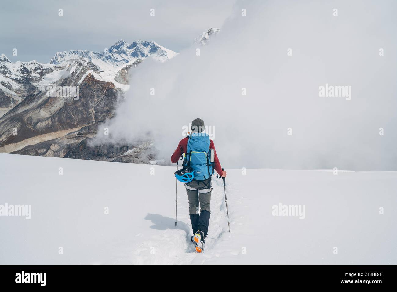 Climber with backpack and trekking poles descending Mera peak high ...