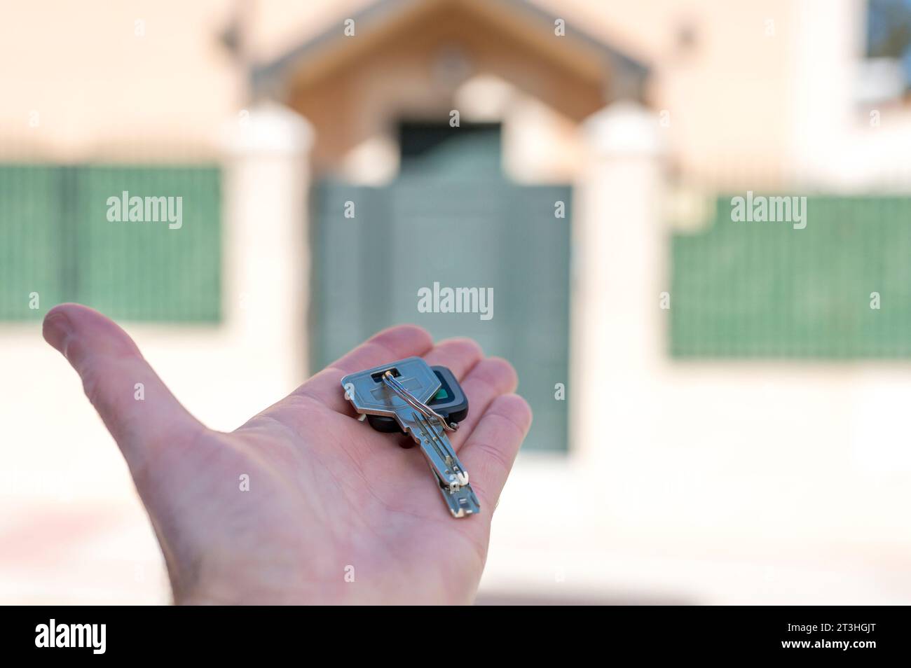 Human hand hold a house key on house background Stock Photo - Alamy