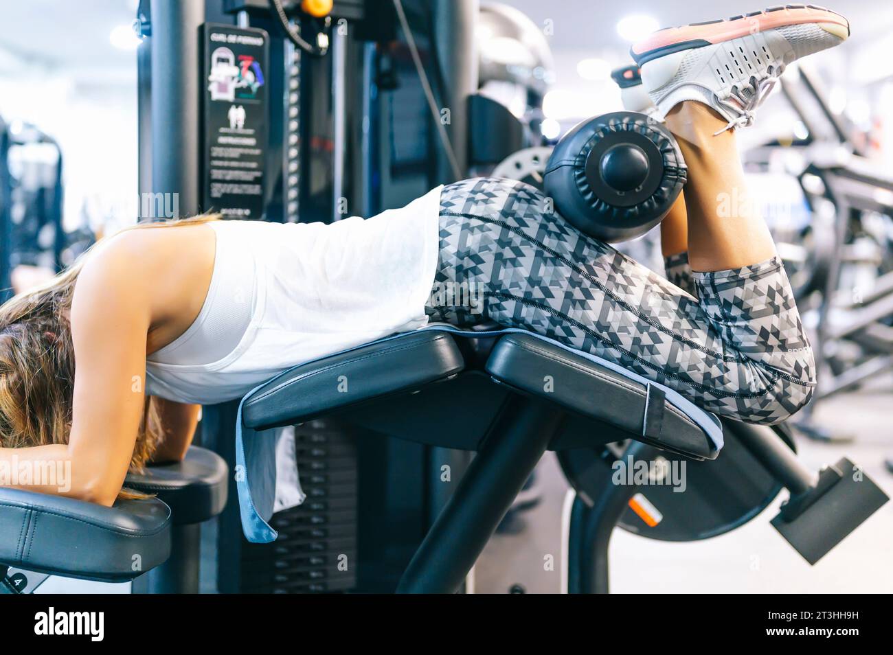Woman strengthening her legs in the gym machine Stock Photo - Alamy
