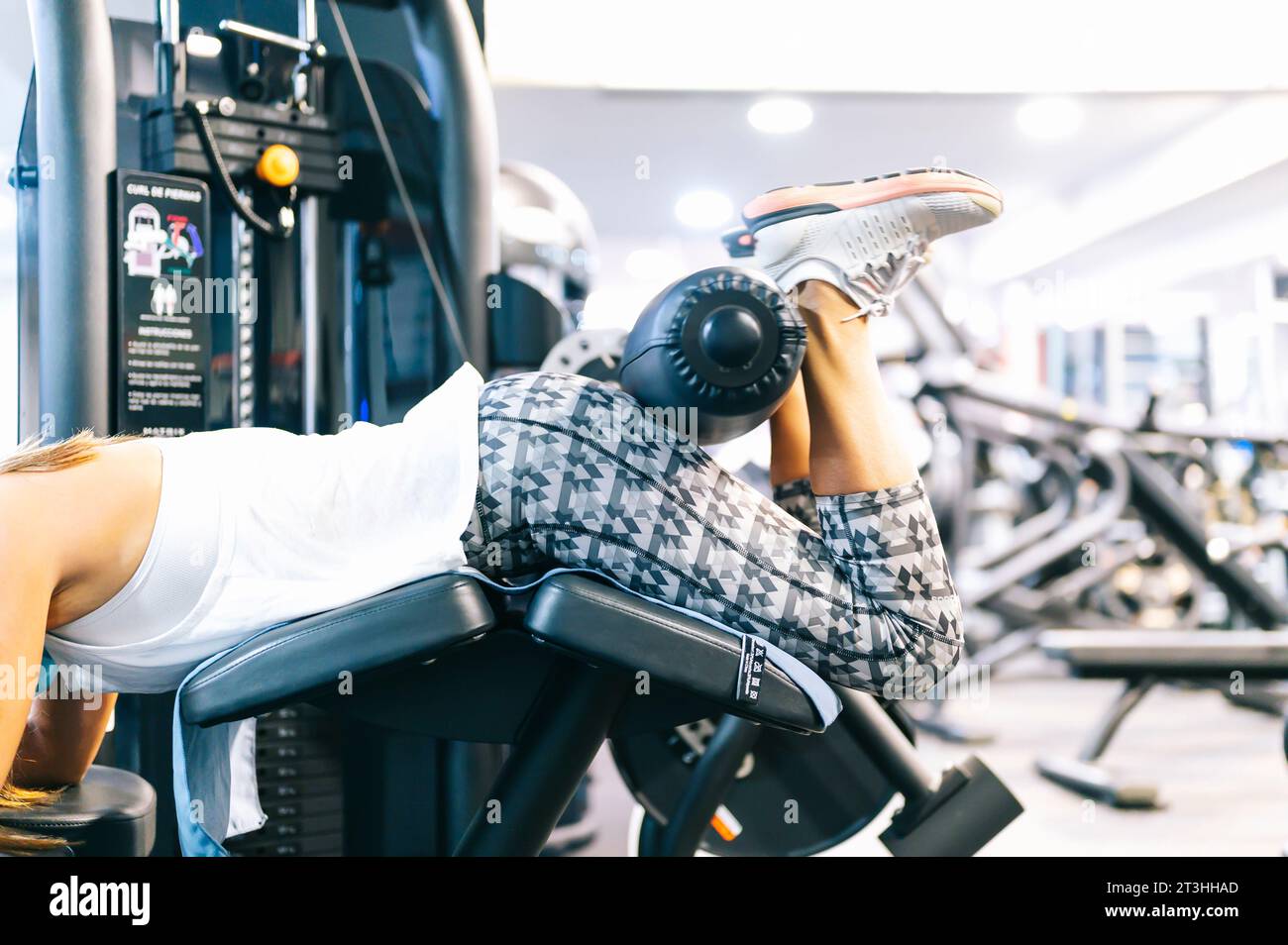 Woman strengthening her legs in the gym machine Stock Photo - Alamy