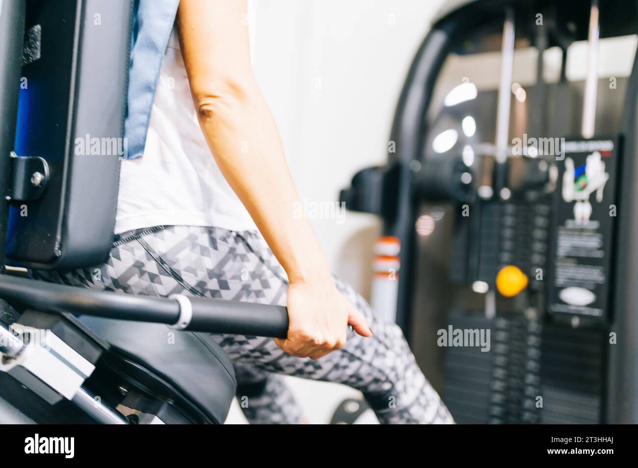 Woman strengthening her legs in the gym machine Stock Photo - Alamy