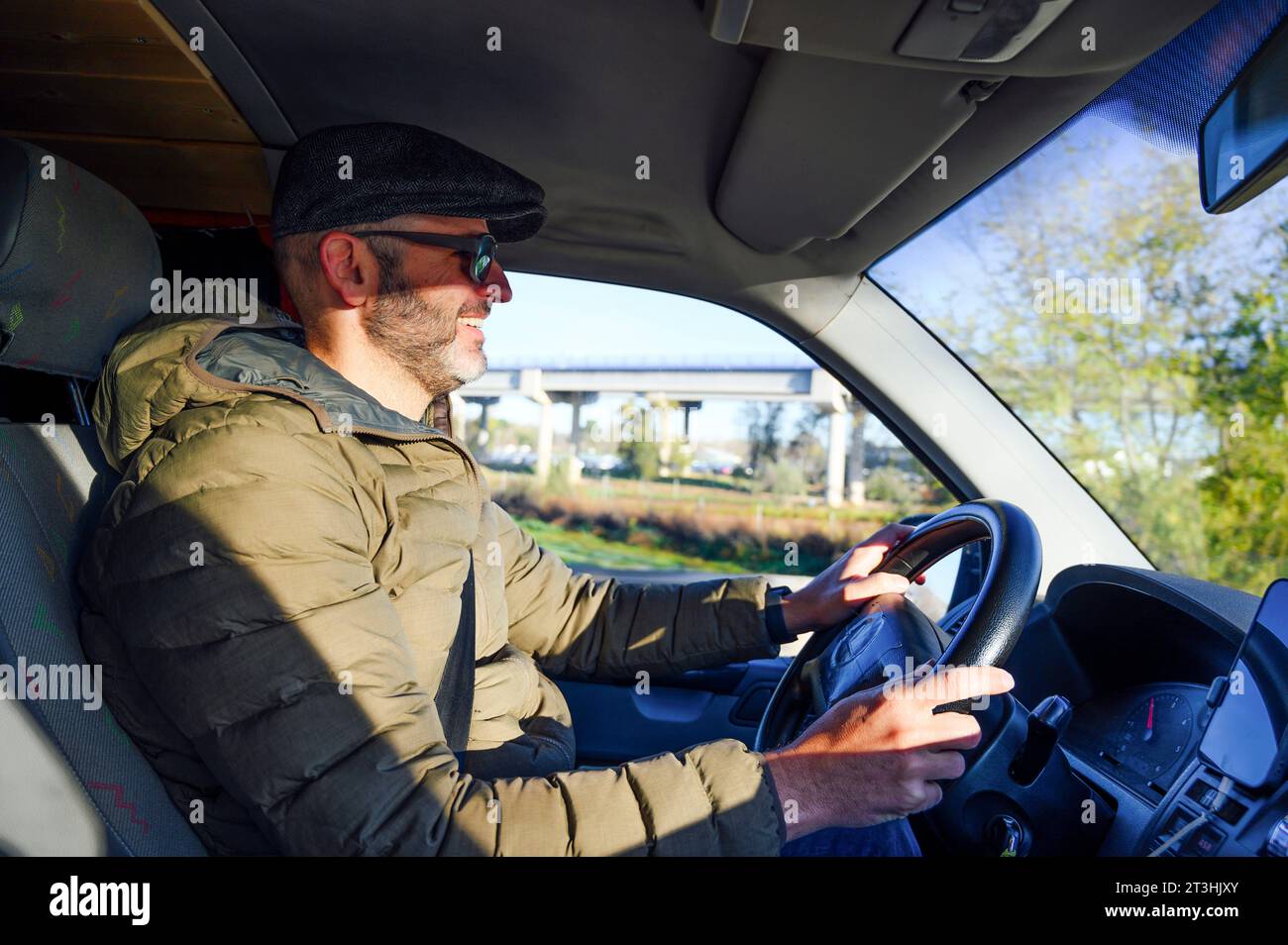 Enjoying his drive. Handsome young man in smart casual wear smiling ...