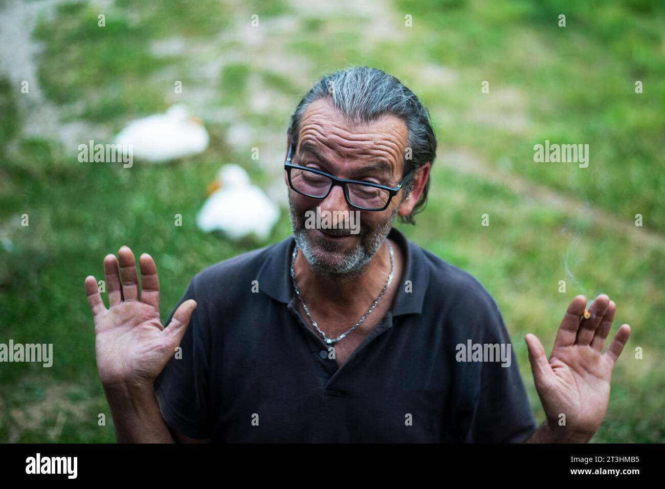 A 60-year-old Serbian man, exuding vitality, with glasses, long hair ...
