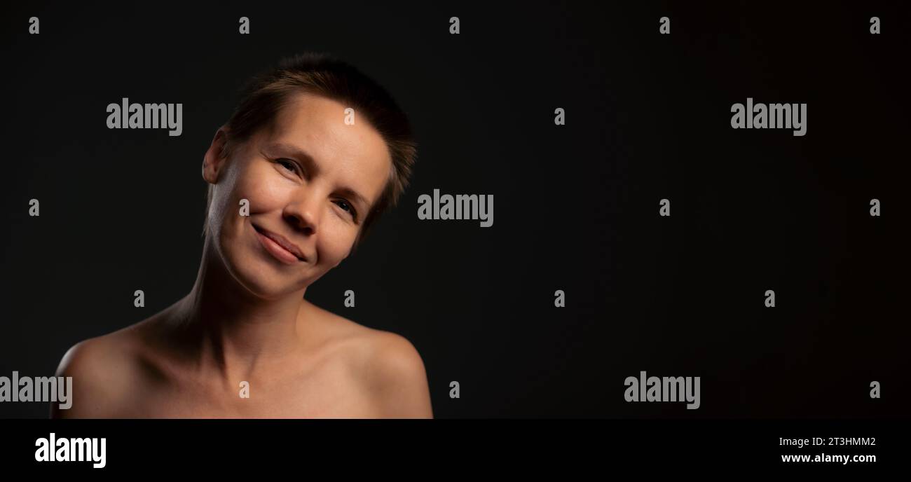 Capturing a middle-aged lady, short-haired, baring her shoulders ...