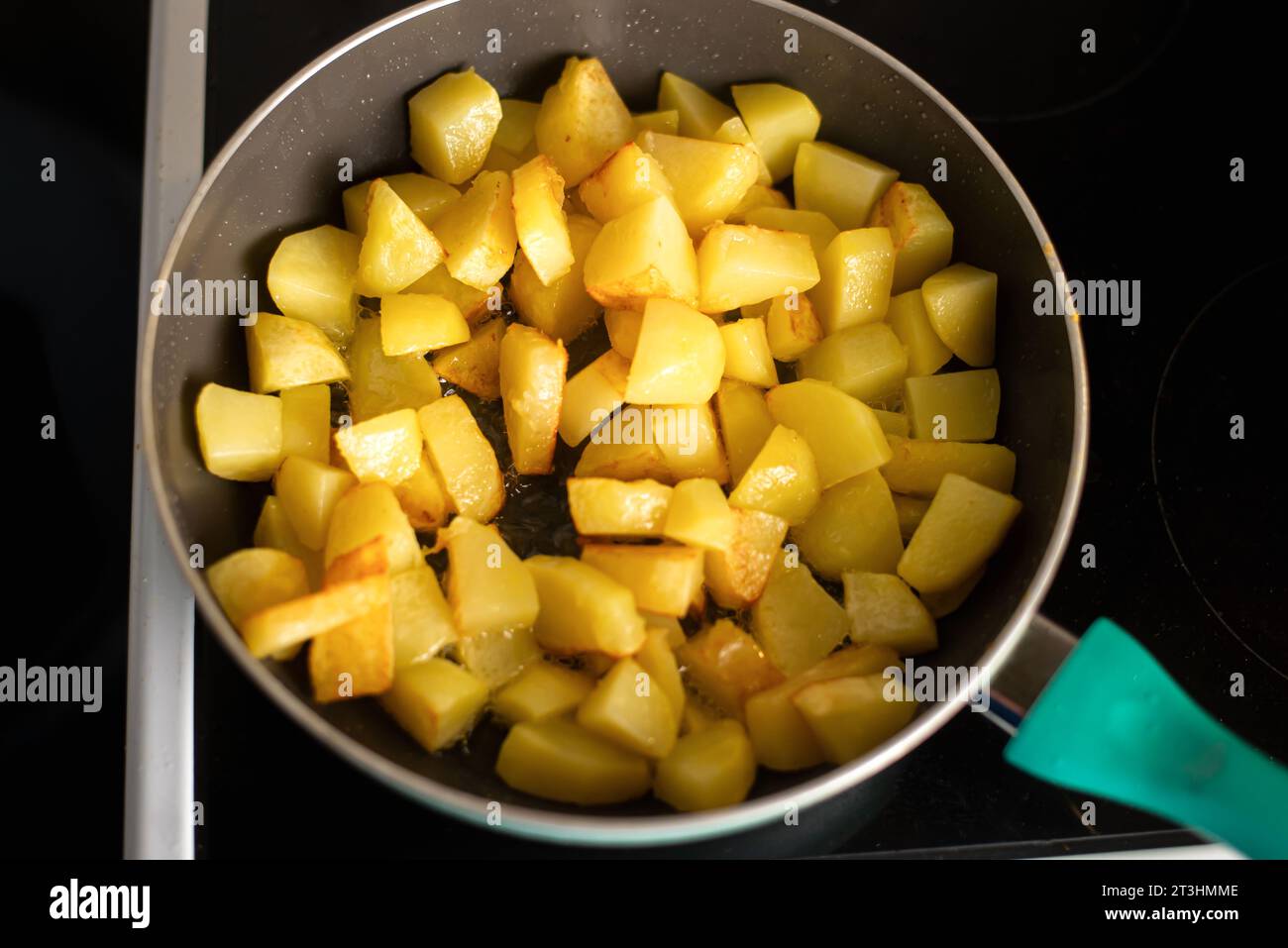 Crispy potato cubes frying in a pan on the stovetop Stock Photo - Alamy