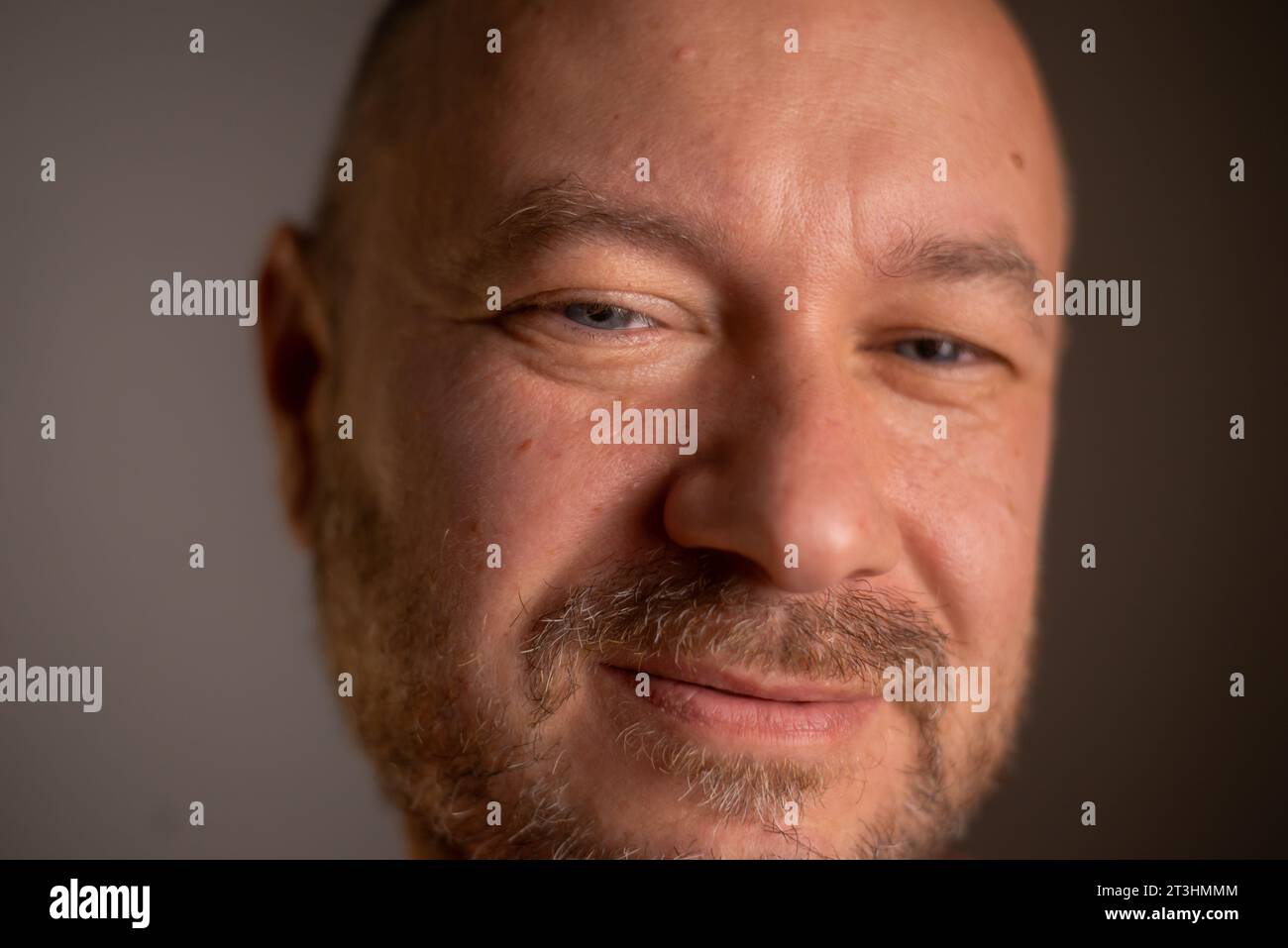 Close-up of a 40-year-old man, unshaven, with an amiable expression and ...