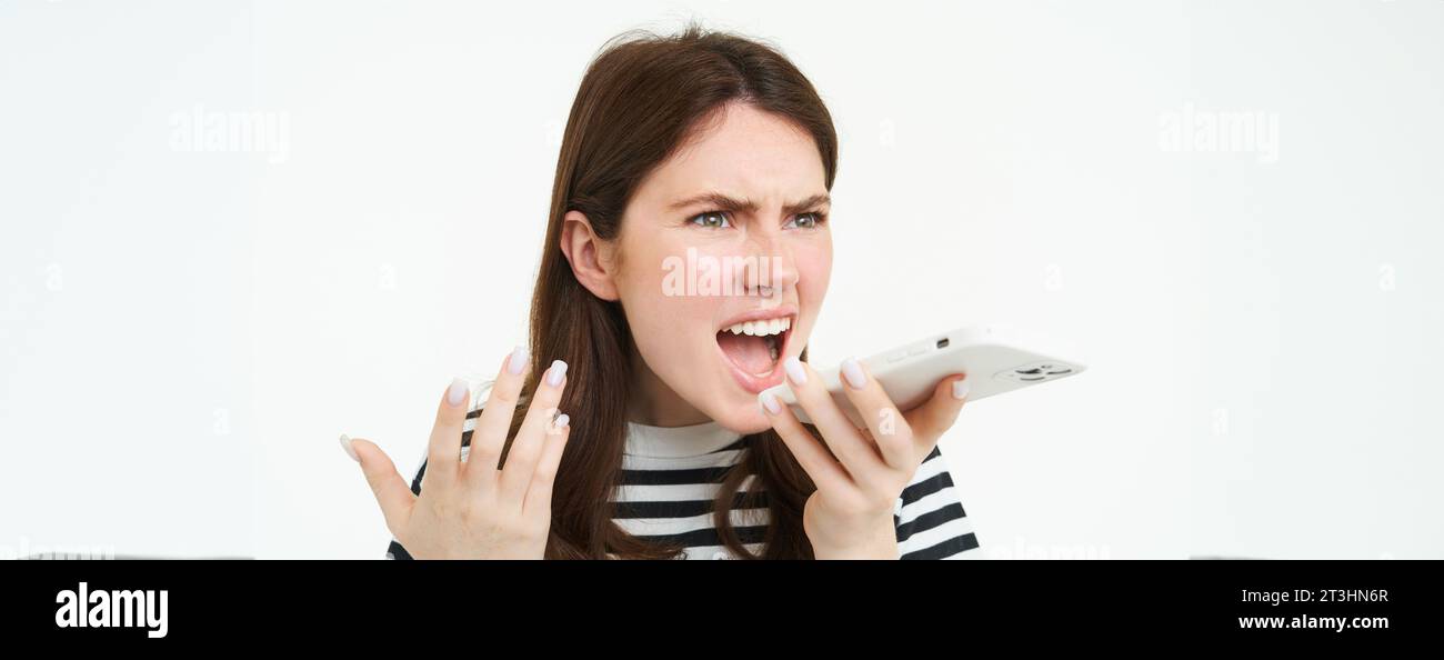 Portrait of angry woman shouting at smartphone speakerphone, recording ...