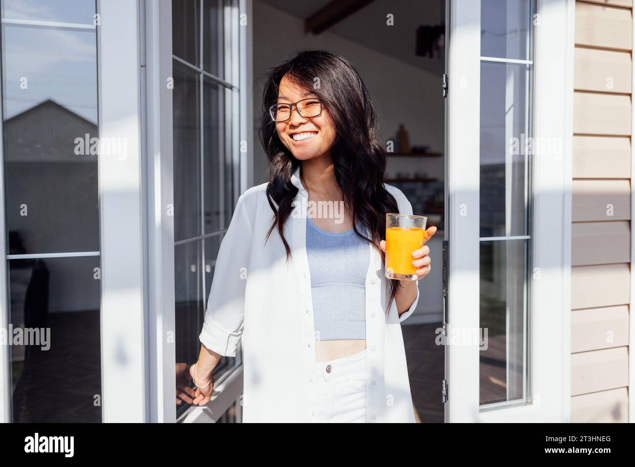 Young cute Asian woman opens glass door and goes out onto veranda of ...