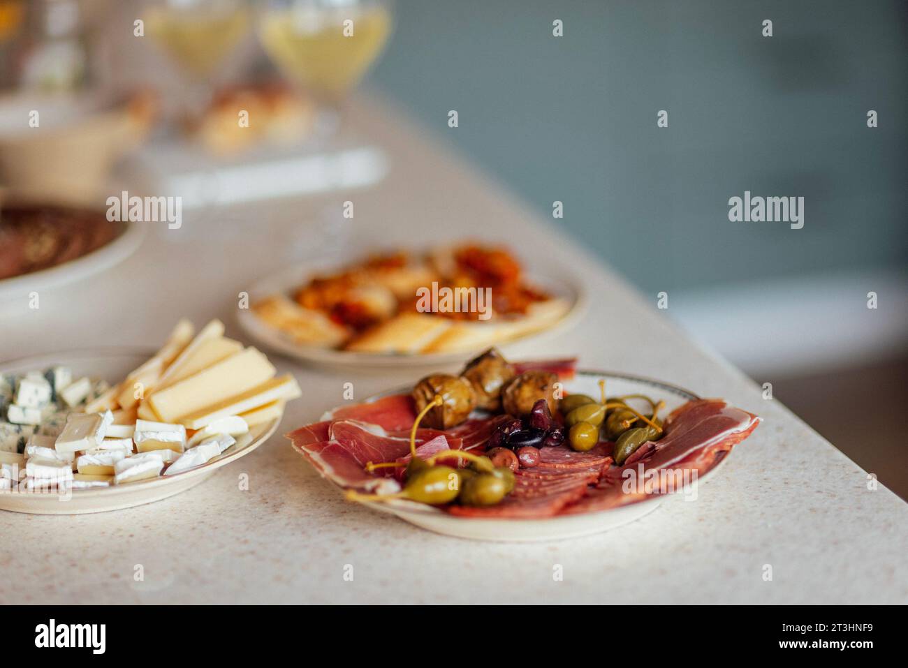 Two glasses of cool champagne and plates with various snacks on a table ...